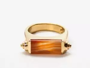 Инспириран од архитектурата од средината на векот, прстенот „Нова“ се одликува со позлатен месинг од 18 карати во комбинација со рачно исечен полускапоцен камен од агат. Рачно изработен во Њујорк, овој прстен е истовремено минималистички и луксузен, поставувајќи ја вашата година со стил.