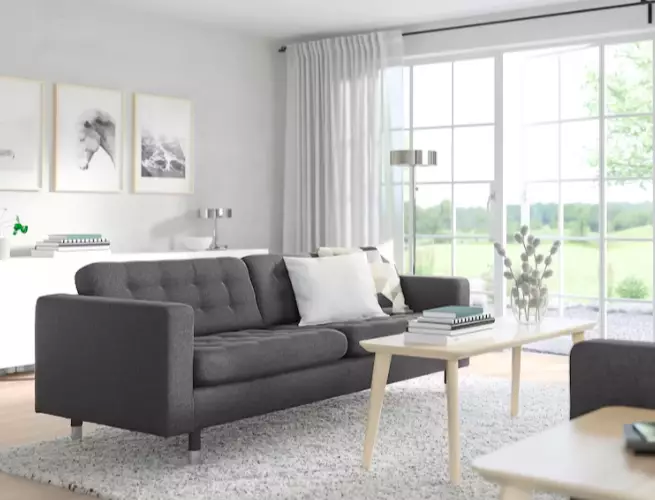 grå tuftet sofa i solrig stue