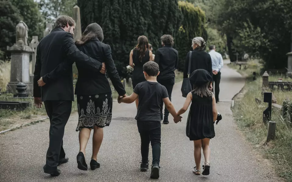 o familie îmbrăcată pentru o înmormântare