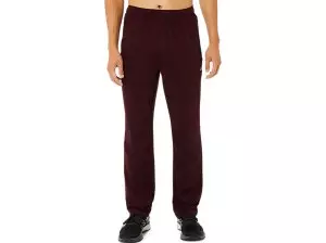 Home con pantalóns de correr granate e tenis negros