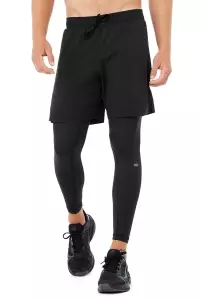 Fekete Alo Yoga Stabilitás 2 az 1-ben nadrágot viselő férfi
