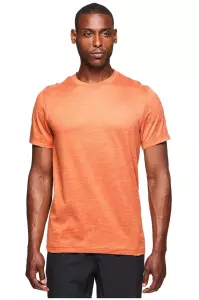 Mies, jolla on yllään oranssi jooga-t-paita ja mustat shortsit