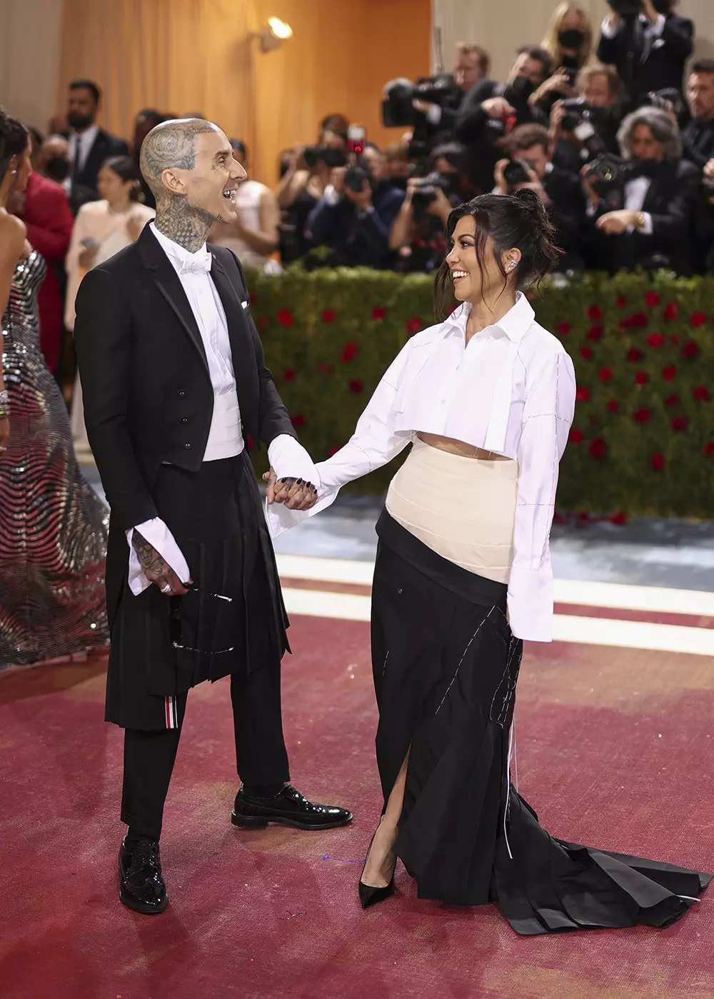 Kourtney Kardashian a Travis Barker nosí Thom Browne na Met Gala 2022 oslavující In America: Anthology of Fashion. Každoroční akce se konala v The Metropolitan Museum of Art v New Yorku dne 2. května 2022.