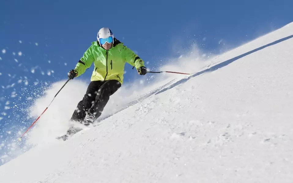 مردی که روی تپه بدون ابر اسکی می کند