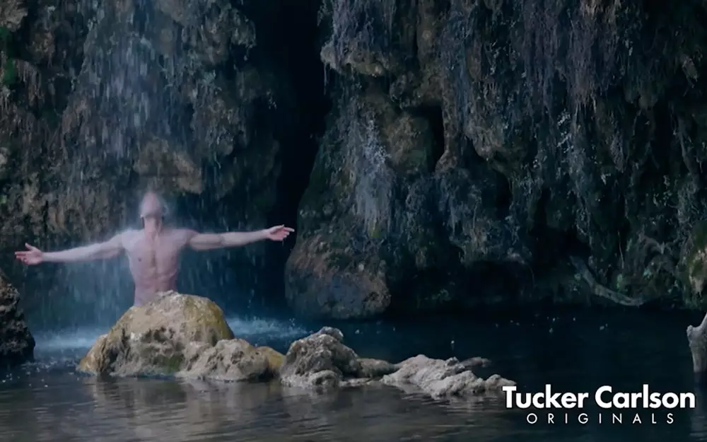 Een man zonder shirt baadt in een waterval in het einde van mannen omstanders tucker carlson