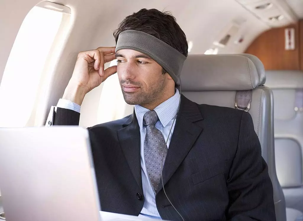 Ta naglavni trak za slušalke vam pomaga bolje spati na letalu