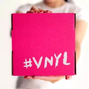 गुलाबी पृष्ठभूमि पर VNYL लोगो, विनाइल रिकॉर्ड सदस्यता सेवा