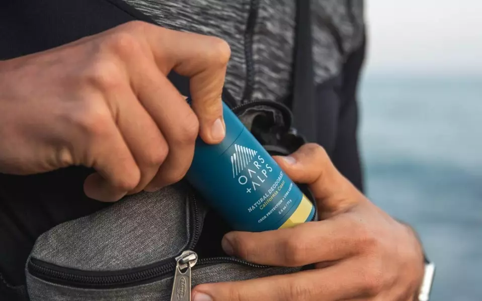 Hawak ng lalaki ang Oars + Alps deodorant