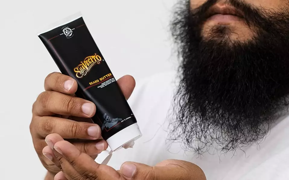 Бородатий чоловік вичавлює масло для бороди Suavecito