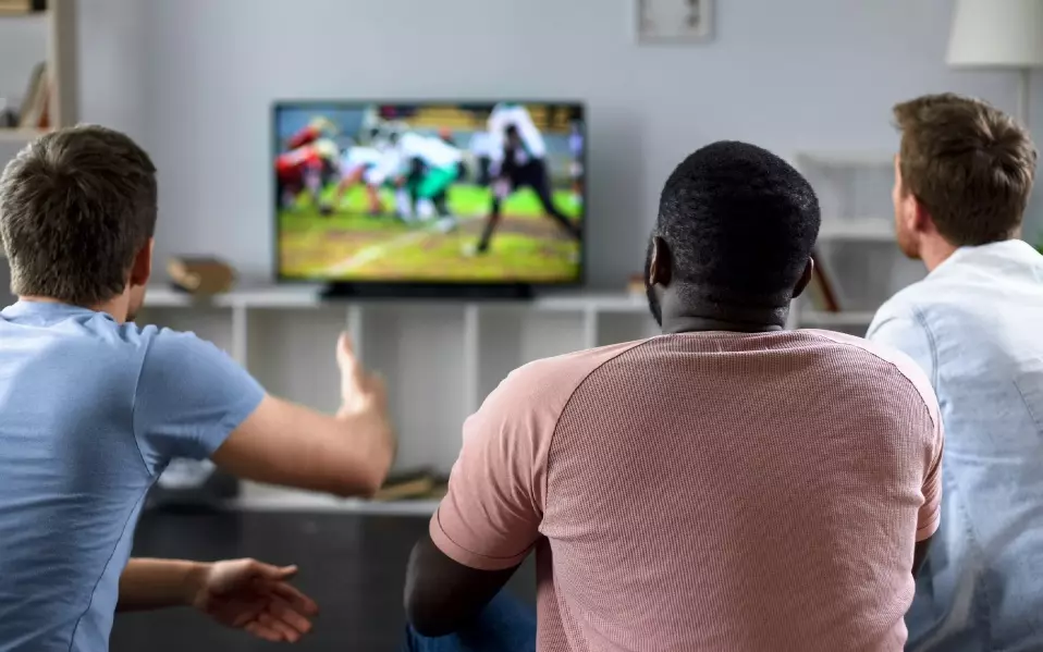 Mužští přátelé se scházejí, aby sledovali fotbal