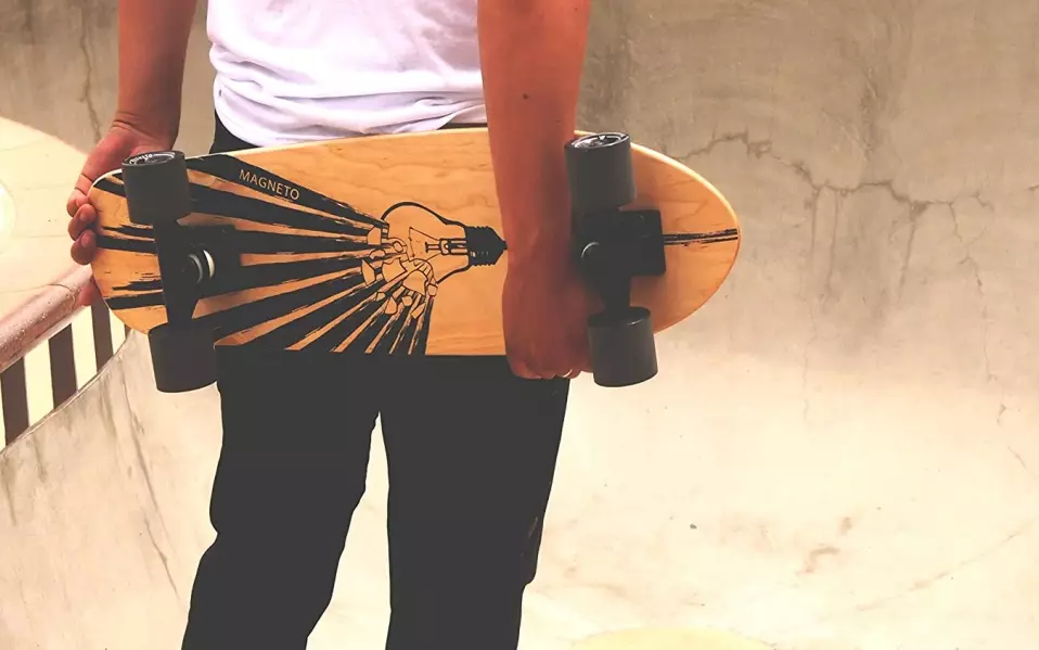 Muškarac drži Magneto Mini Cruiser Skateboard