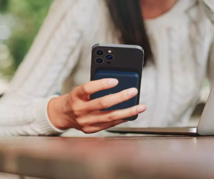 menina segurando o telefone sendo carregado por