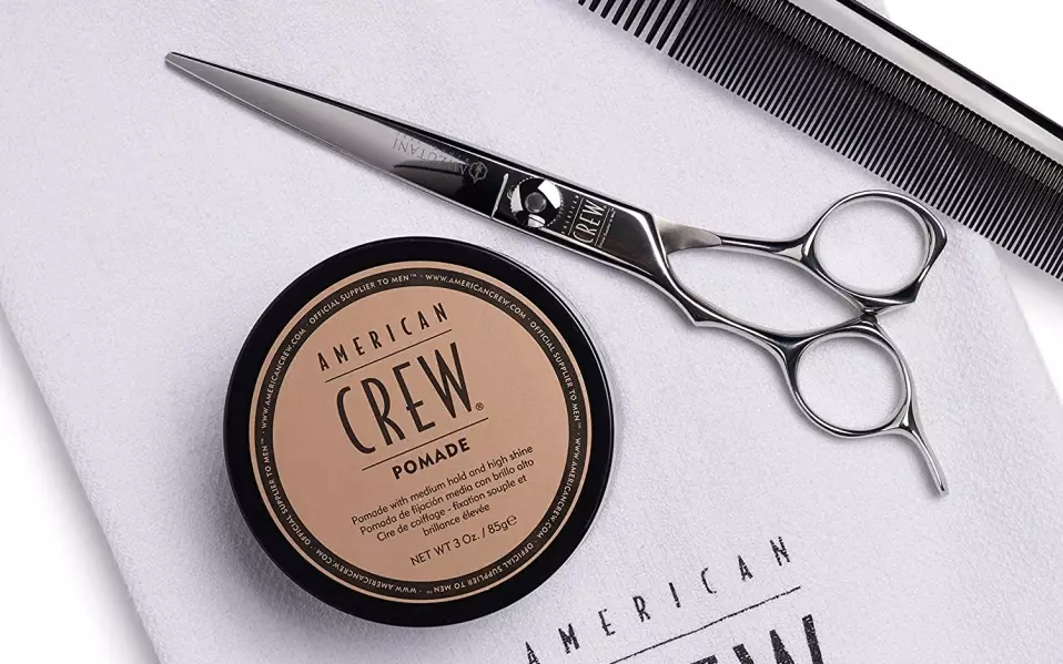 American Crew Pomade s'asseu sobre una tovallola