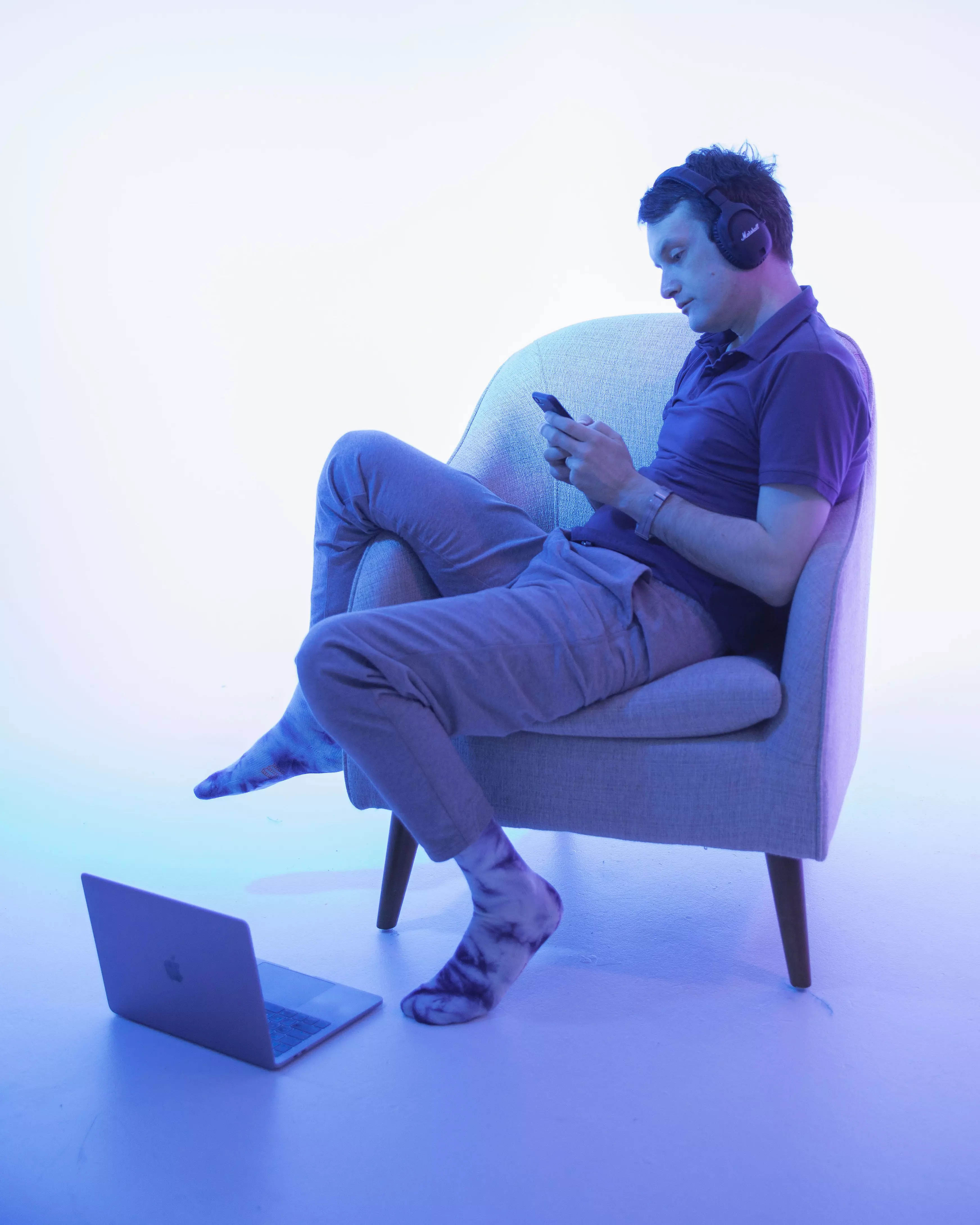 manlike model sit op stoel en werk op telefoon en skootrekenaar, man-toekennings 2020