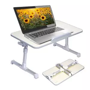 хавтгай гадаргуу дээр босоо сууж буй неетто эвхдэг орны тавиурын ширээ, дээр нь цагаан дэвсгэр дээр зөөврийн компьютер сууж байна