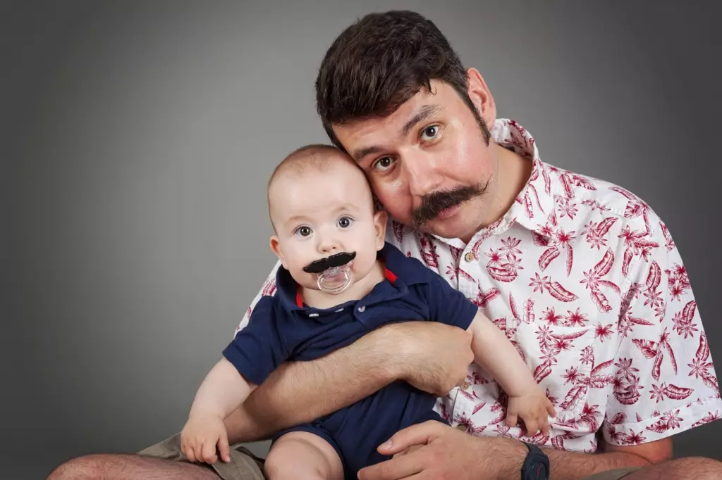 người đàn ông và một em bé đeo ria mép
