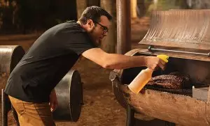 Aaron Franklin pulverizando carne nun fumador de churrasco