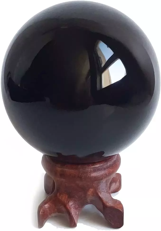 bola de cristall negre i base de fusta