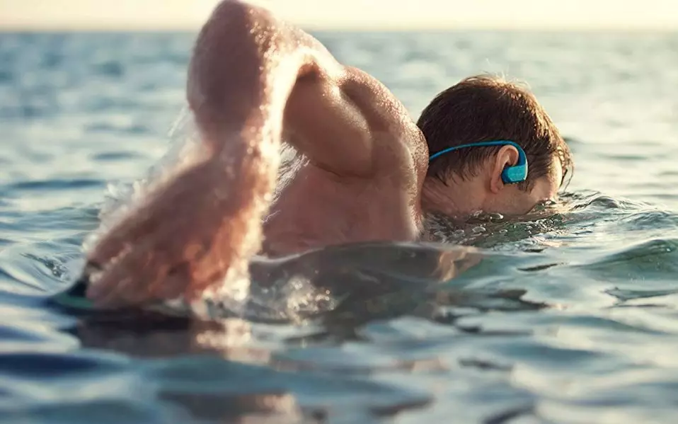 Mies uimassa mp3-kuulokkeilla kuuntelemassa